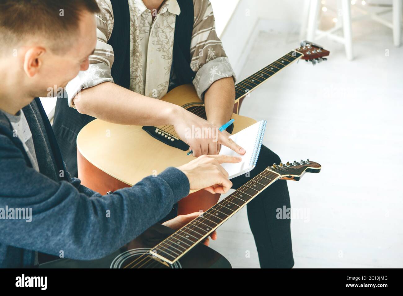 Learning to play the guitar. The teacher explains to the student the ...