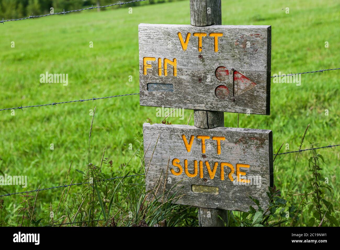 Wooden panel indicating the path for mountain cyclists, in front of a ...