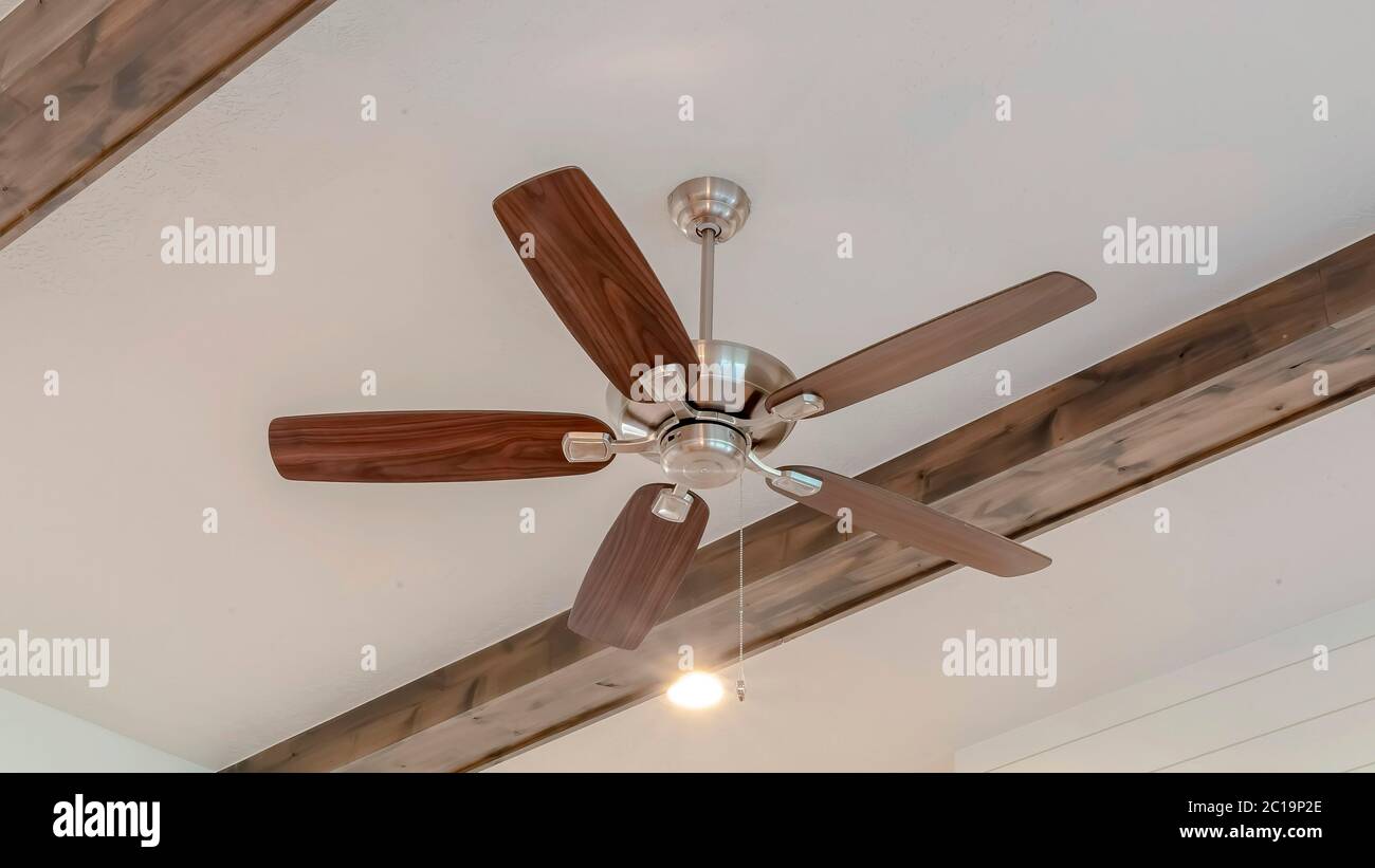 Panorama Ceiling fan with lights between decorative wood beams inside ...