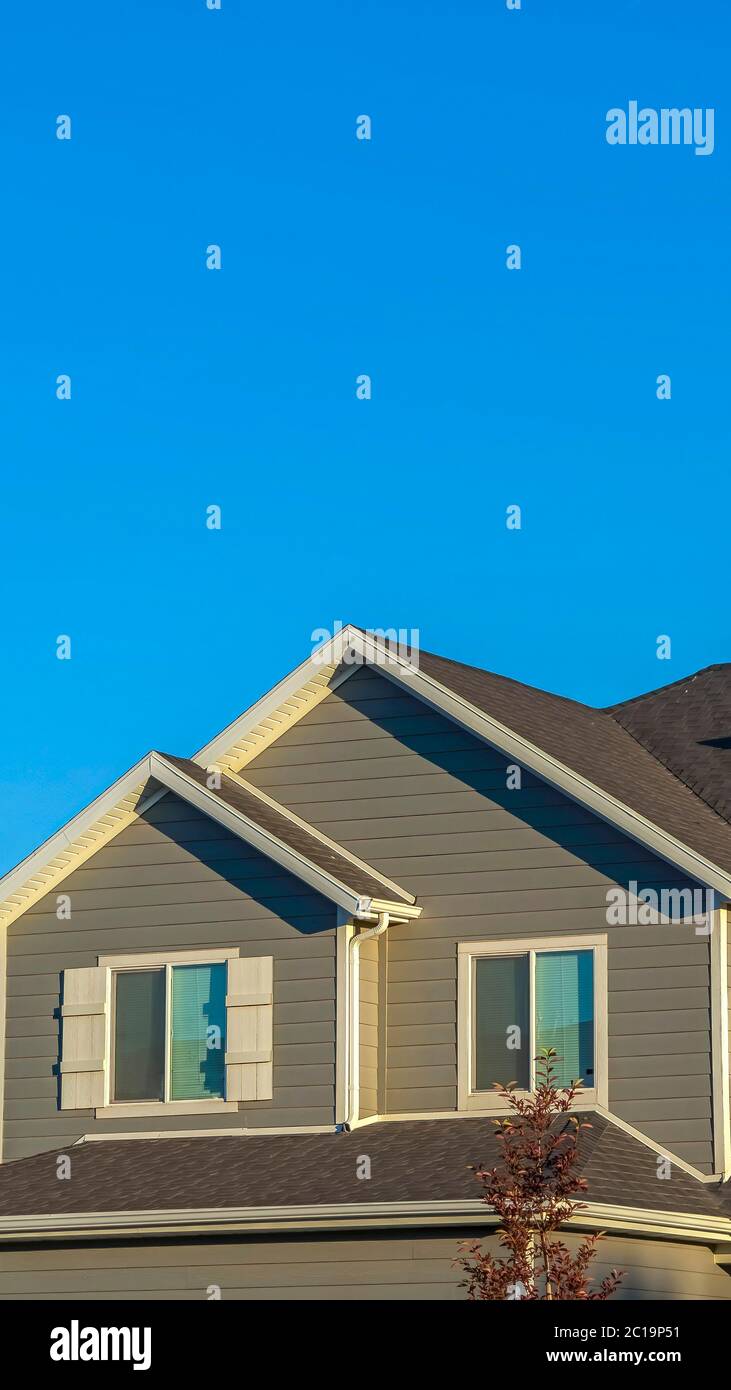 Vertical frame Home exterior with view of the upper storey agaist clear ...