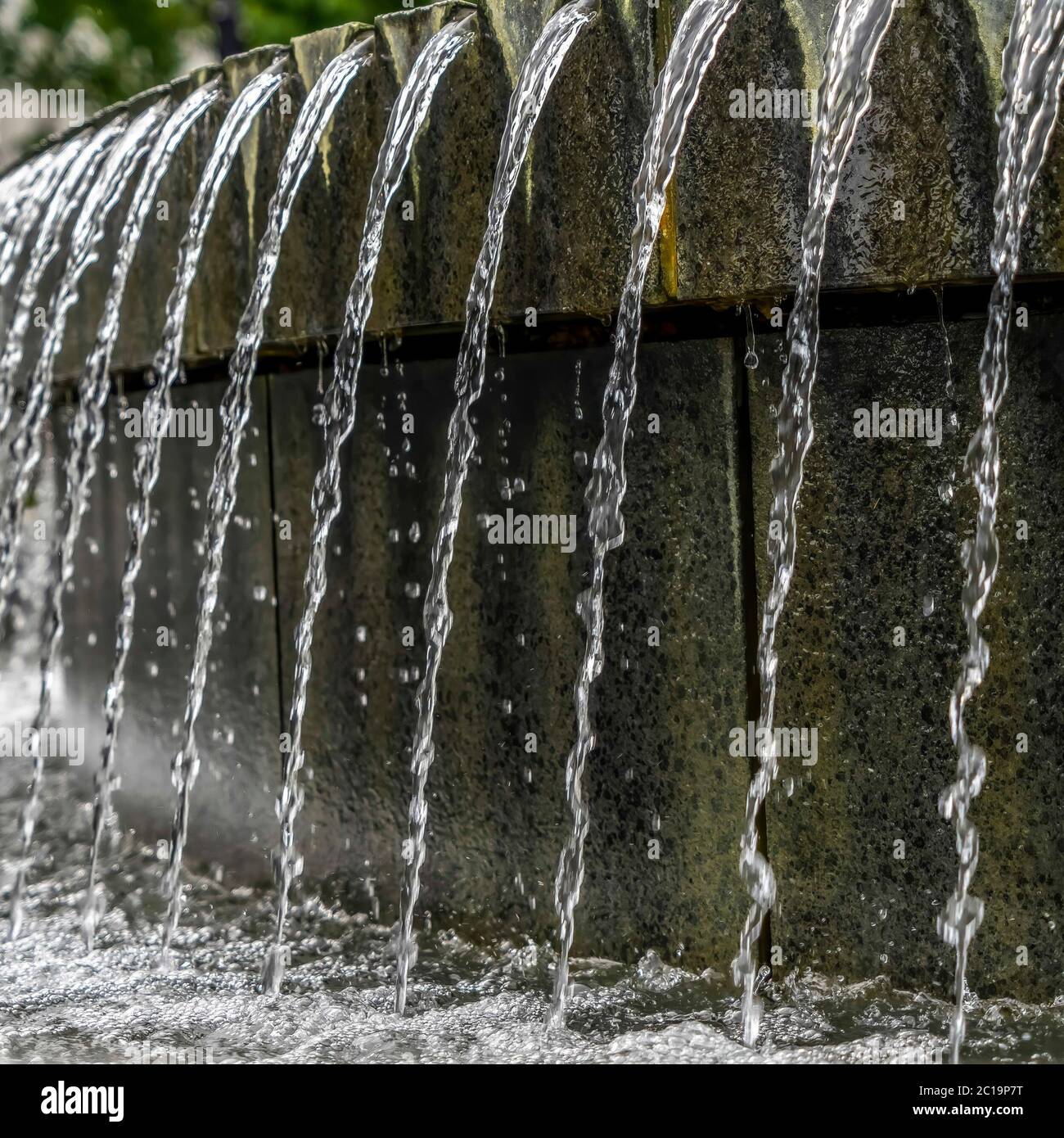 Square crop Cicular stone fountain pool with trickling clear water in ...