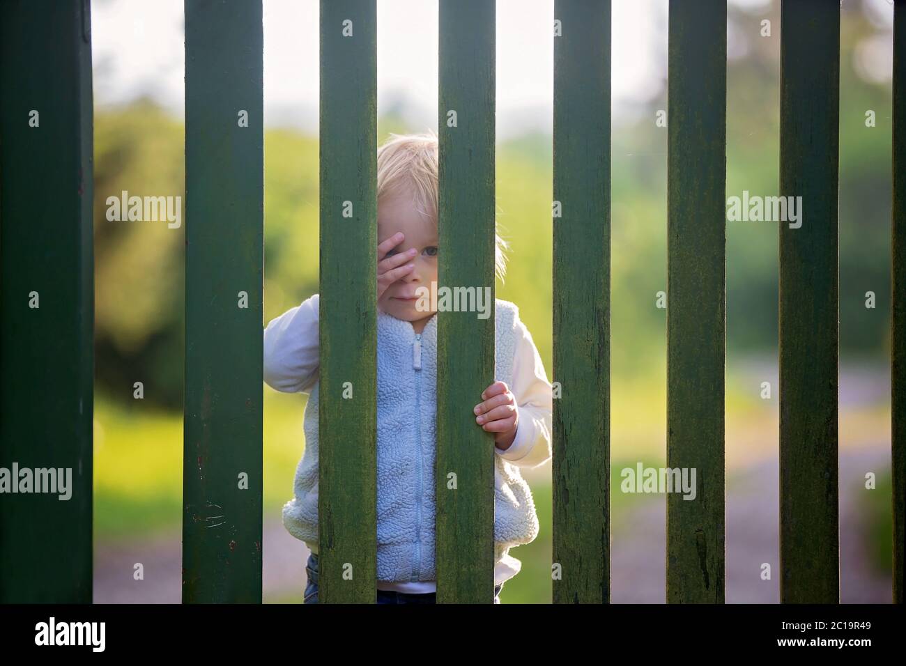 Boy standing behind fence hi-res stock photography and images - Alamy