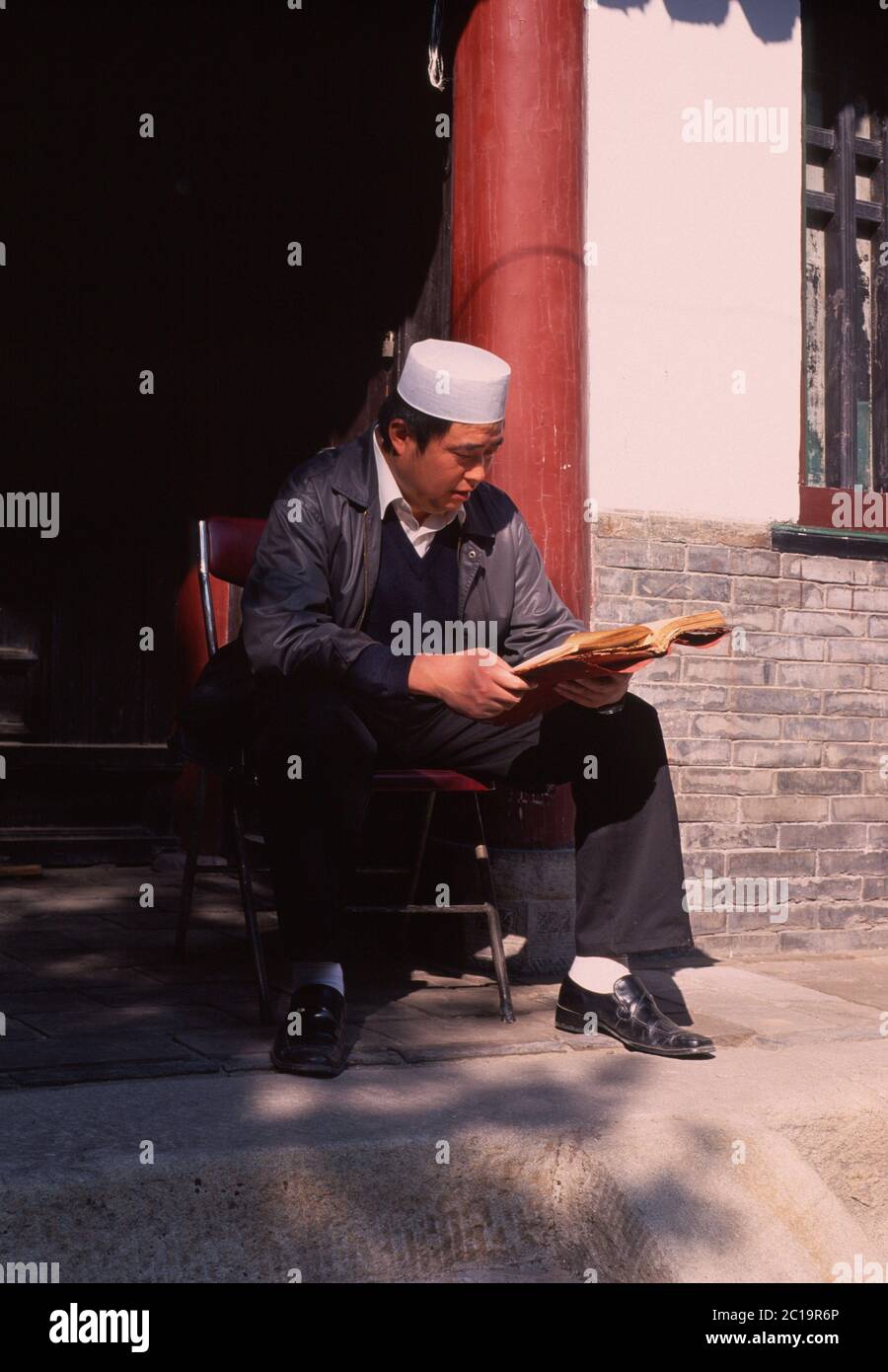 Hui Muslim man reading the Quran at the courtyard of the Great Mosque ...