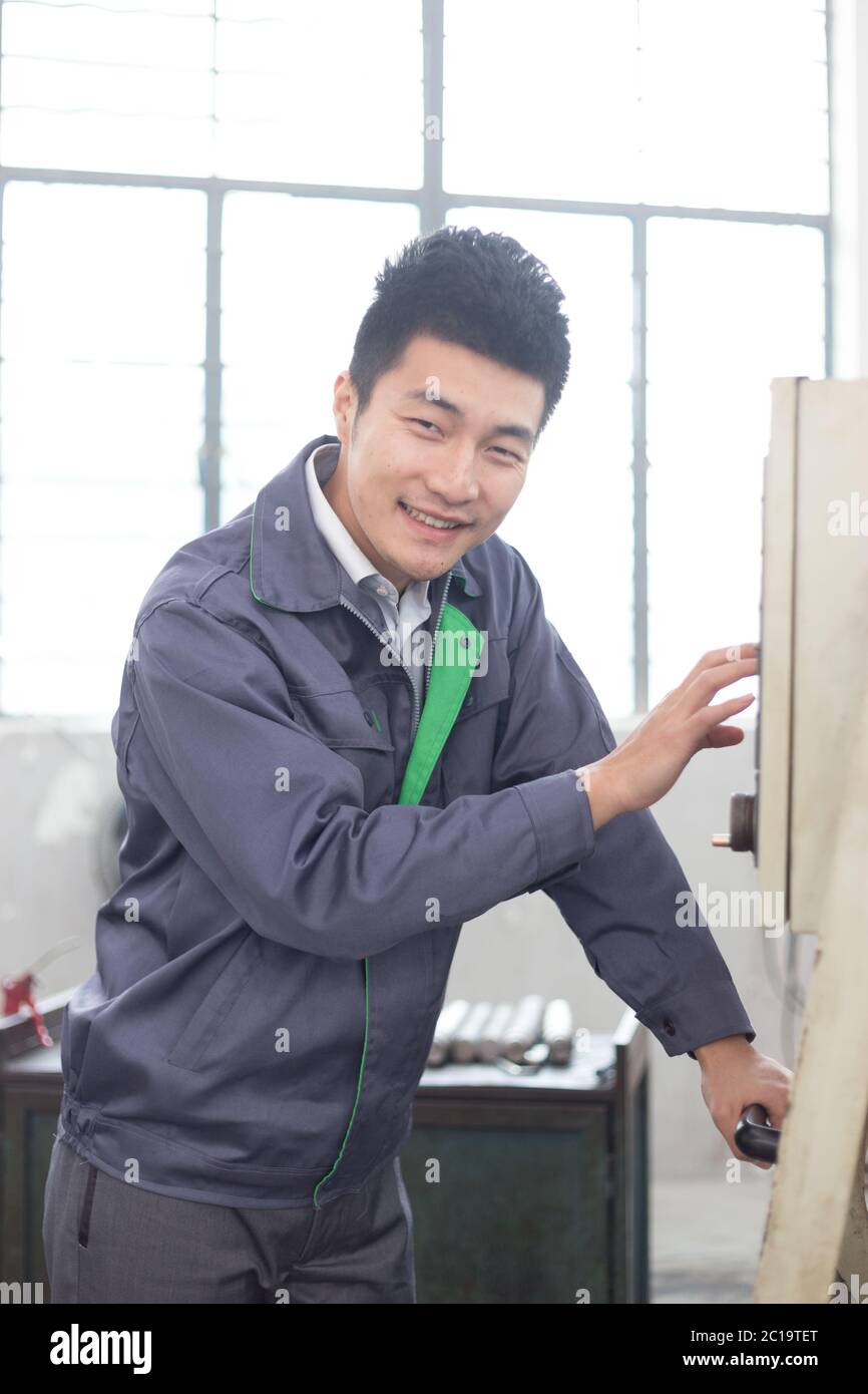 young asian man works in workshop Stock Photo - Alamy