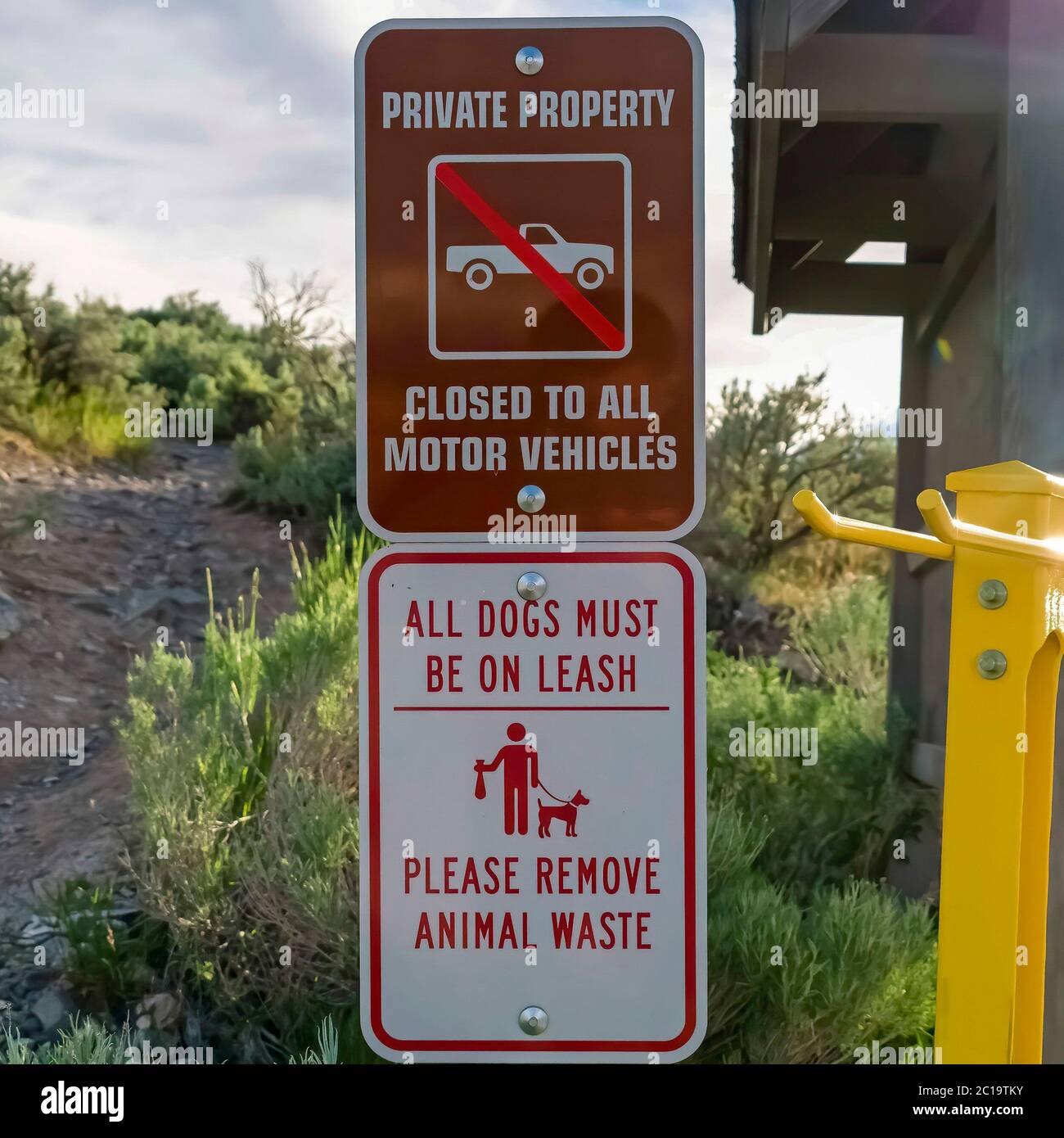 Square Private Property and Pet signs beside a narrow dirt road on a ...