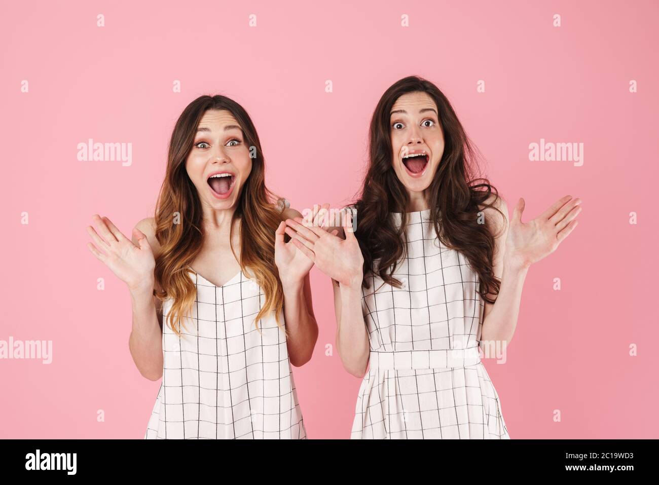 Image of astonished nice women expressing surprise with throwing up ...