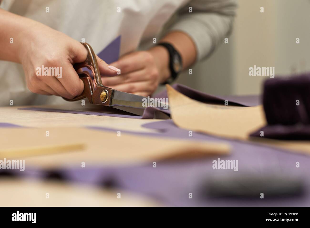 Workplace of seamstress. Dressmaker cuts textile on the sketch lines ...