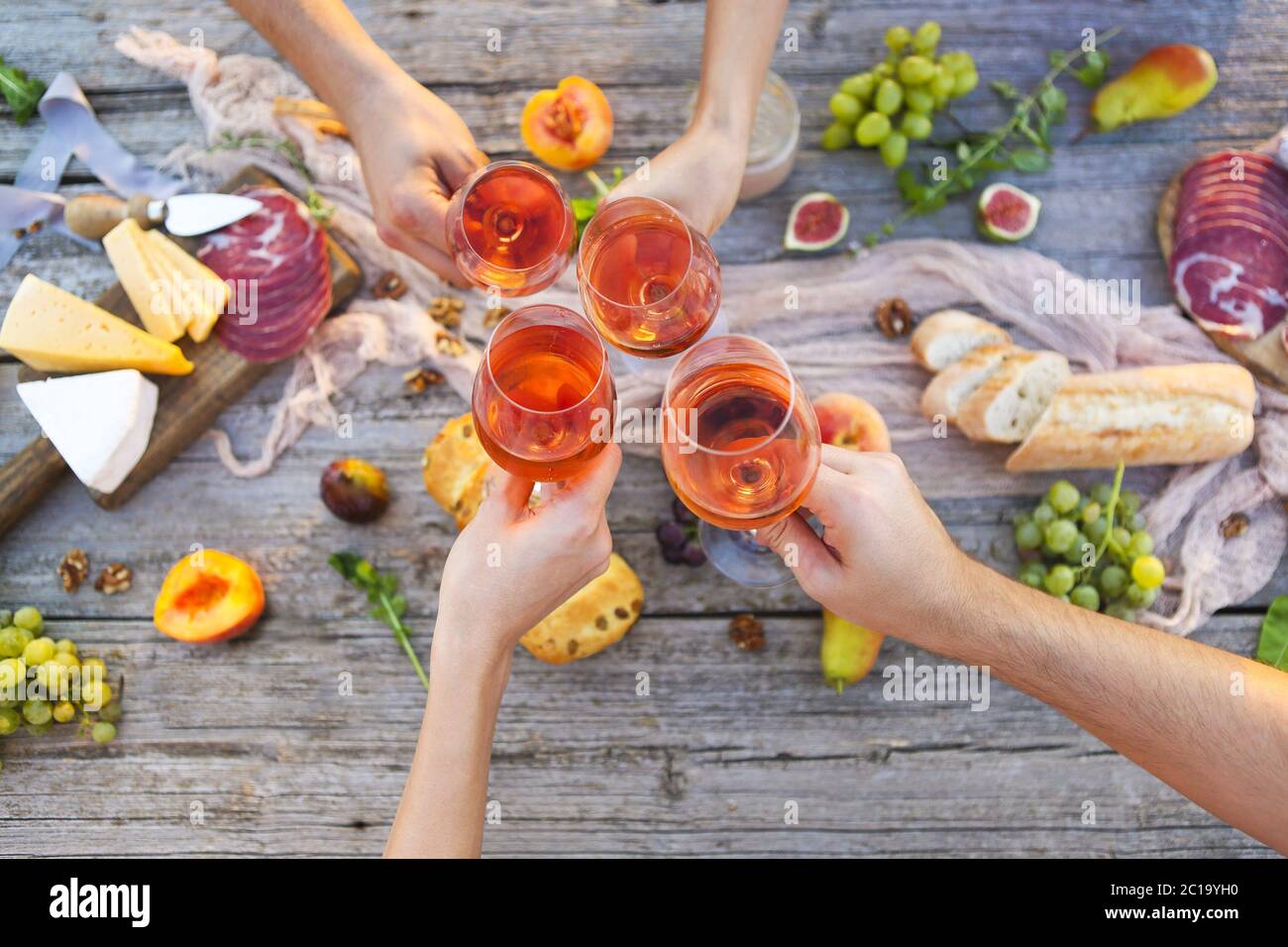 Young people making toast at picnic with rose wine Stock Photo - Alamy