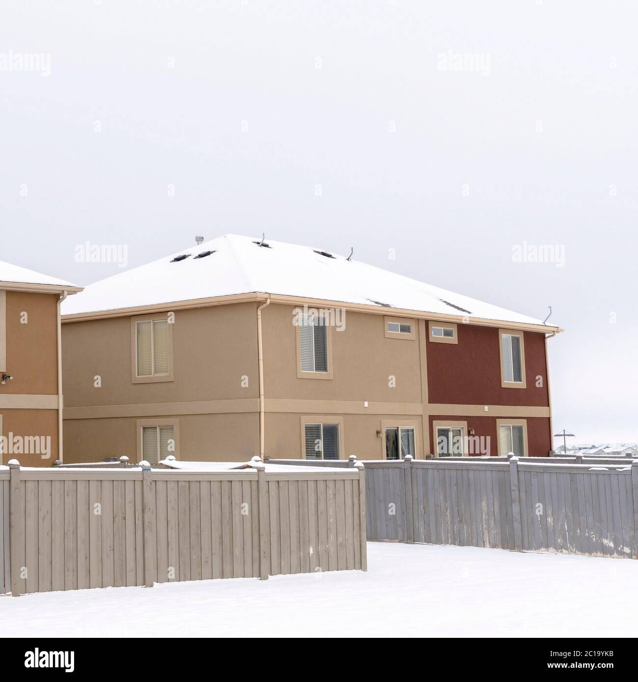 Square crop Homes with hip roofs and wooden fences on a neighborhood ...