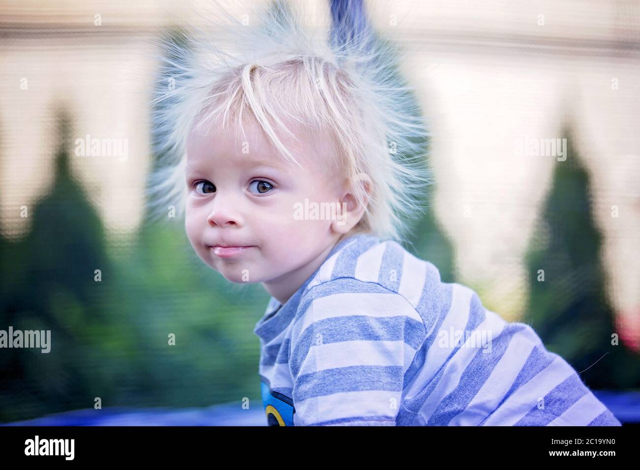Cute little boy with static electricy hair, having his funny portrait ...