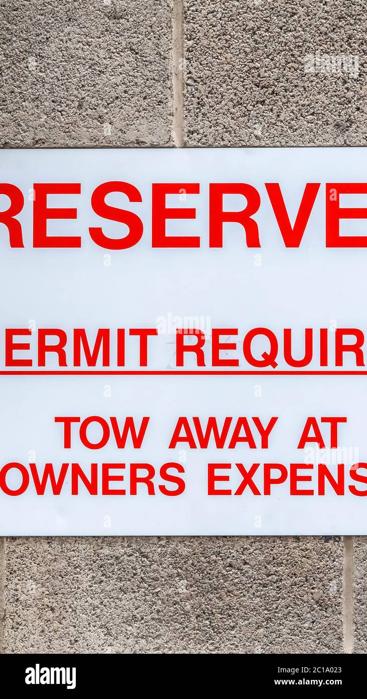 Vertical crop Reserved sign and downspout against wall of building and ...