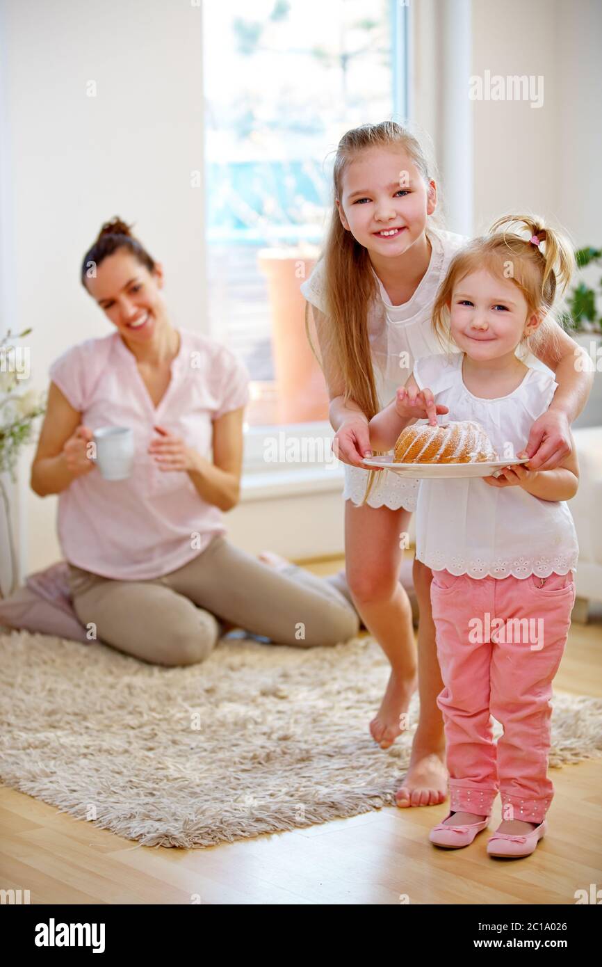 Children with cake for birthday and mother in the background Stock ...