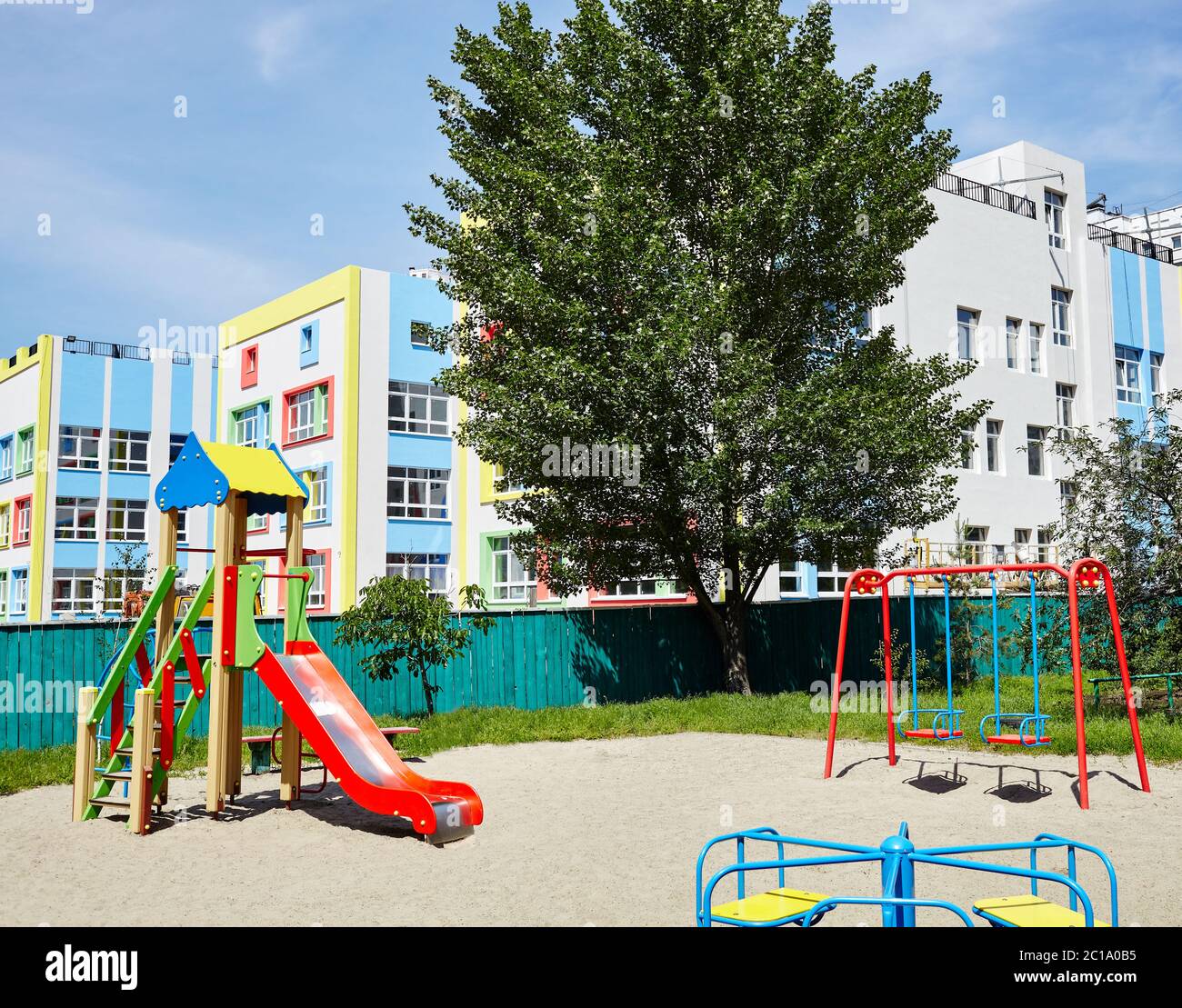 Facade of kindergarten building. Colorful playground for childrens on a ...