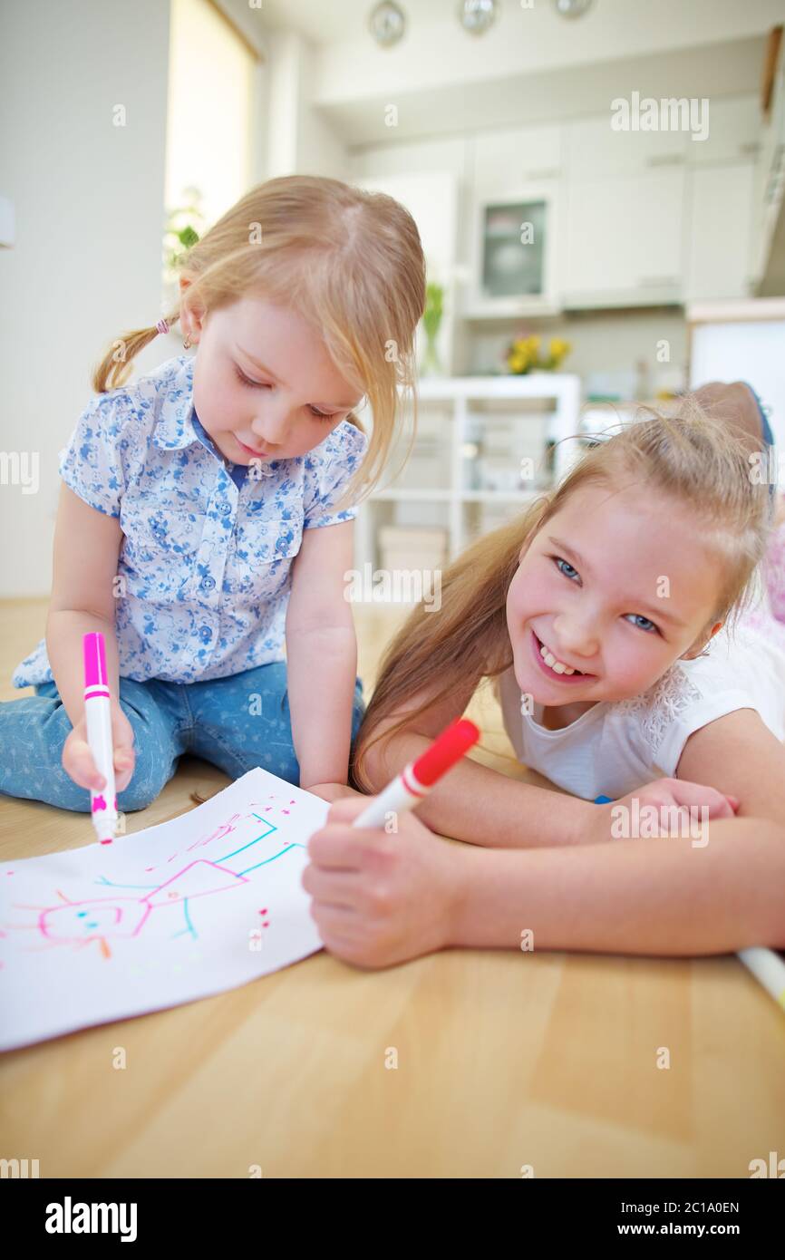 Two girls draw a picture together with felt-tip pens at home Stock ...