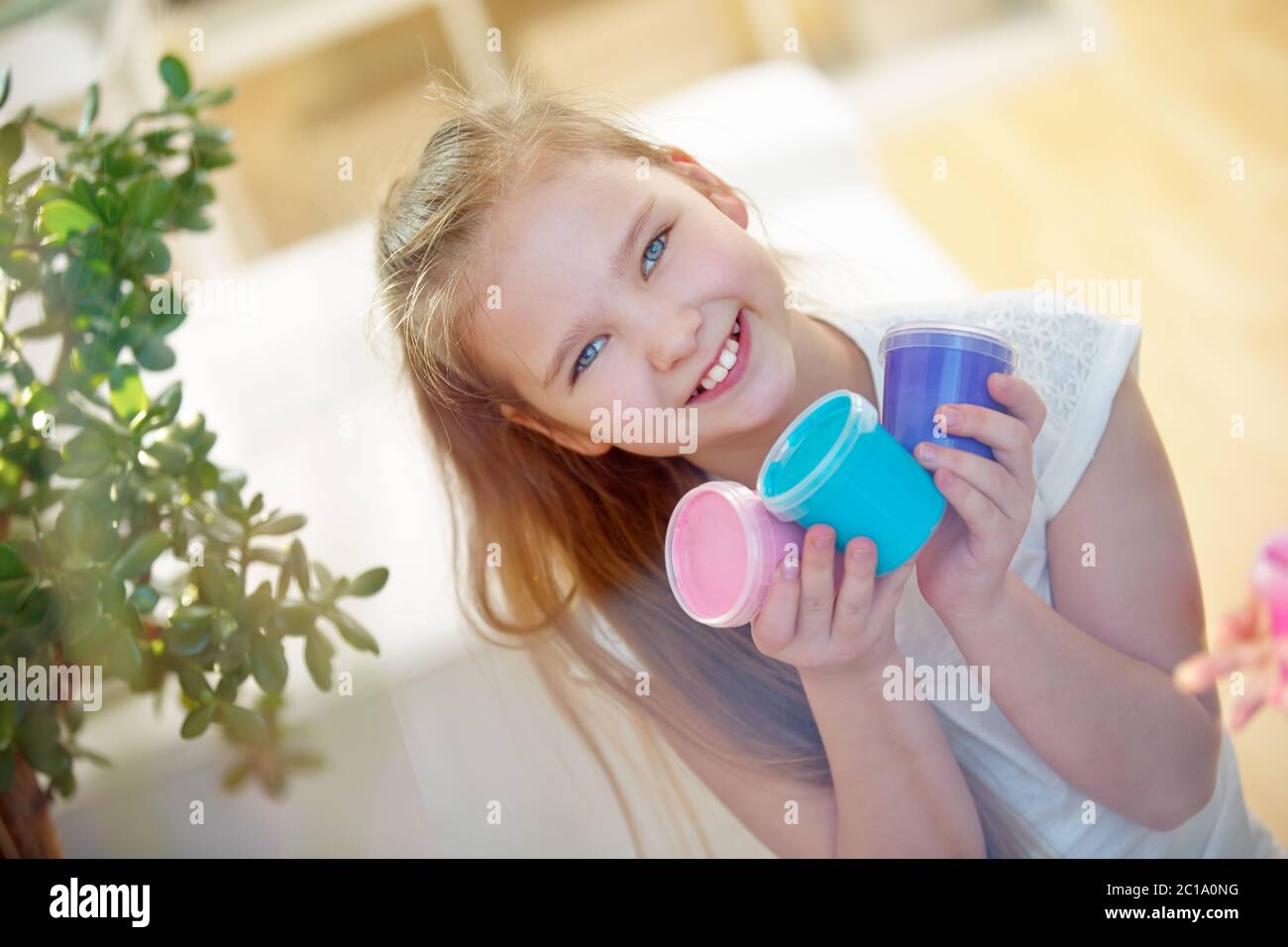 Child holds many different finger colors in pots Stock Photo - Alamy