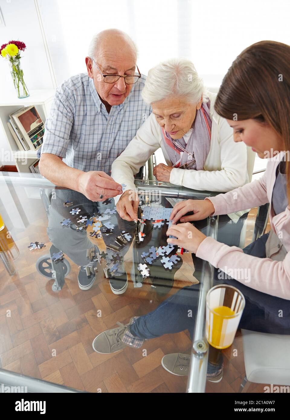 Two senior citizens with social workers solve puzzles as memory ...
