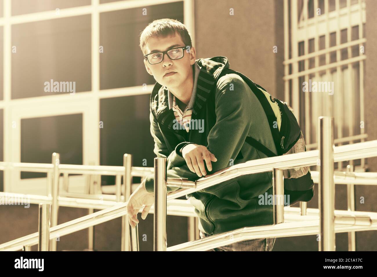 Teen boy with backpack against a school building Stock Photo - Alamy