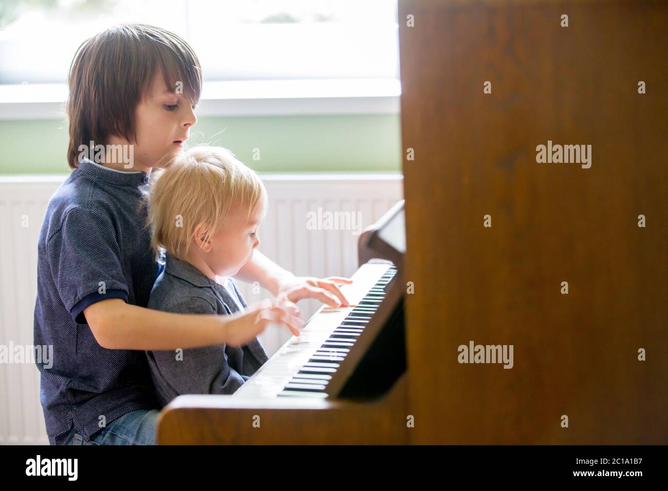 Small toddler boy enjoys playing piano for the first time, having fun ...