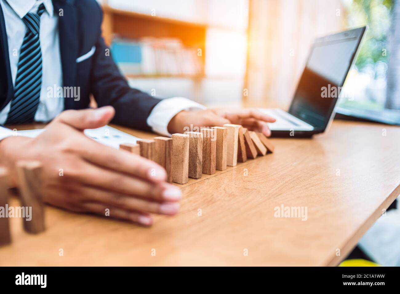 Businessman protect wooden block fall to planning and strategy in risk ...