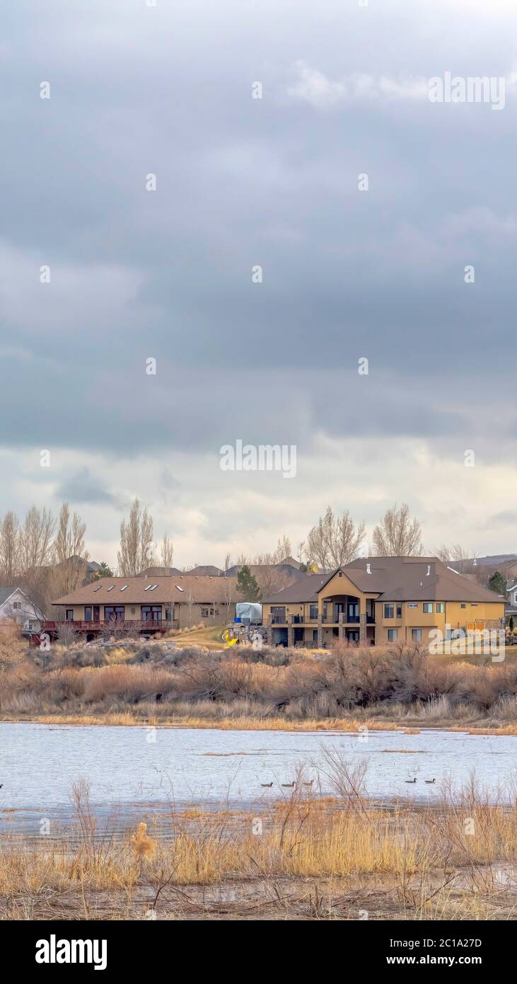 Vertical frame Sky with thick gray clouds over residential landscape ...