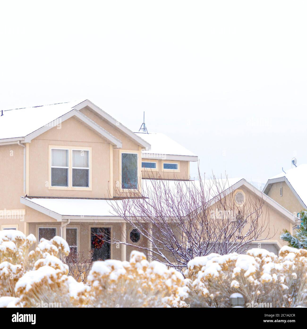 Square frame Snowy home and frosted foliage on a scenic neighborhood ...