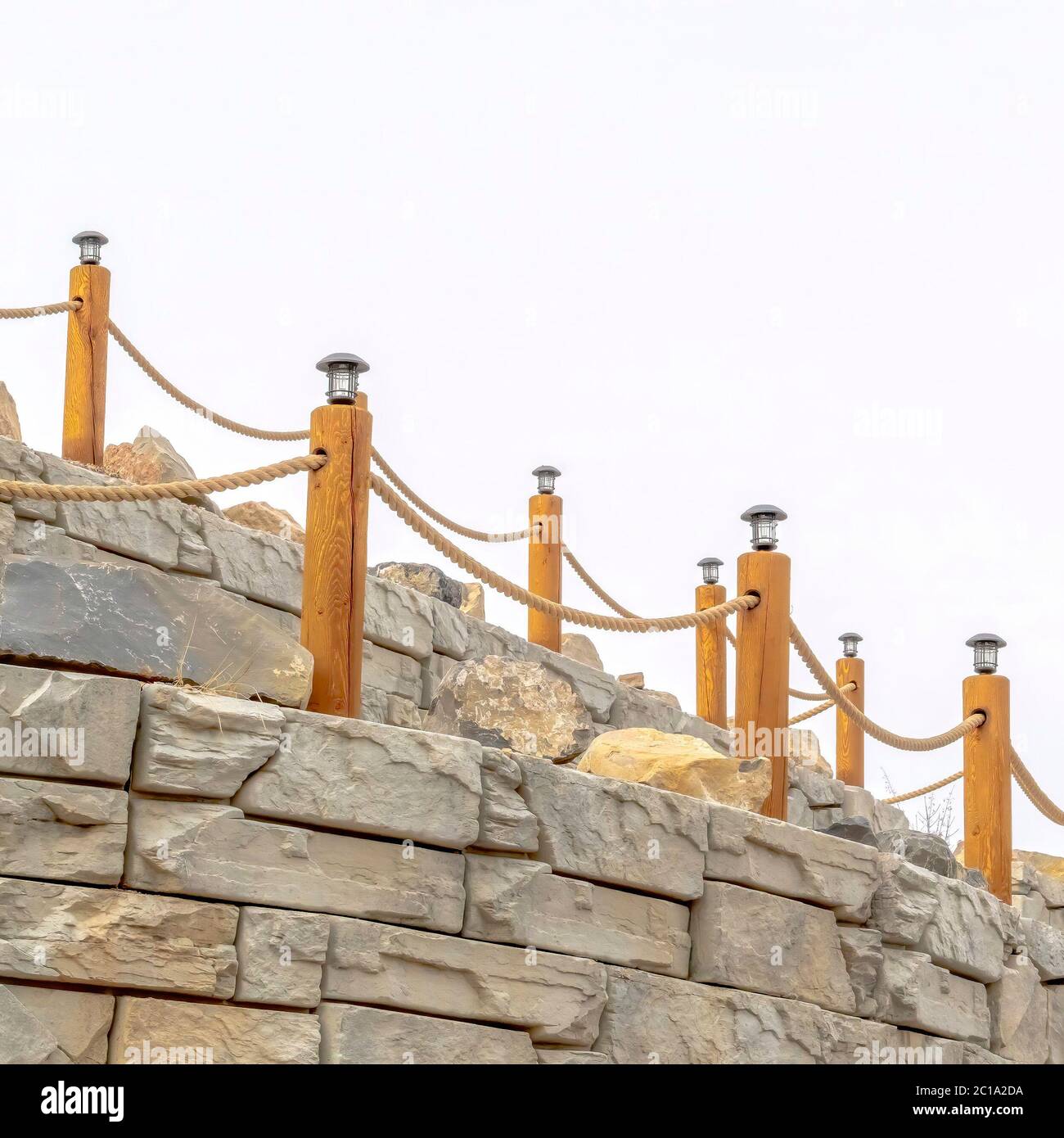 Square frame Rope fence with lamps on posts lining a retaining wall ...