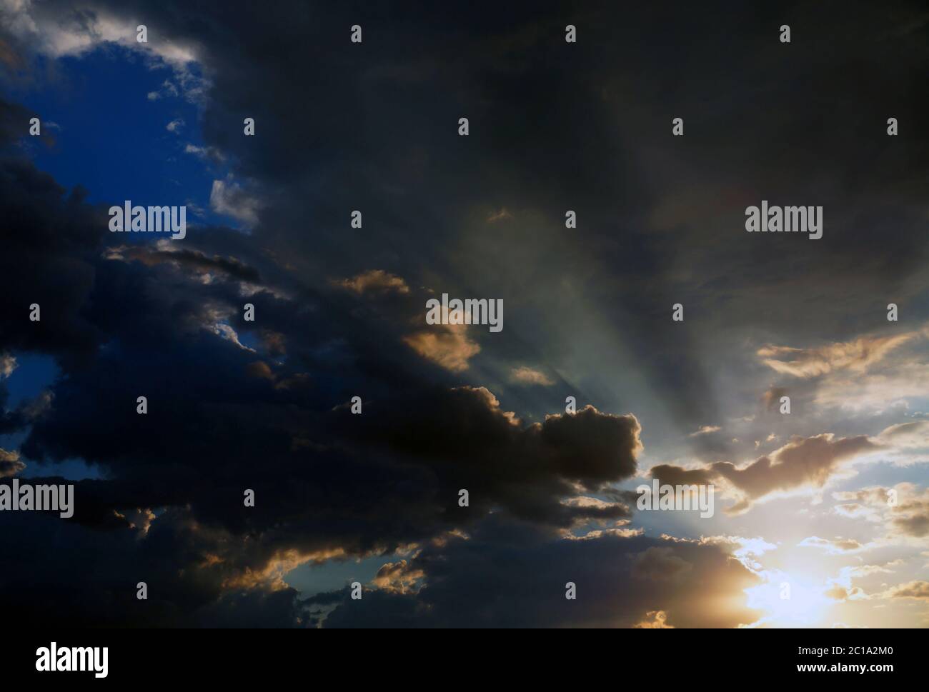 A dangerous sky filled with storm clouds, the sun breaks through the ...