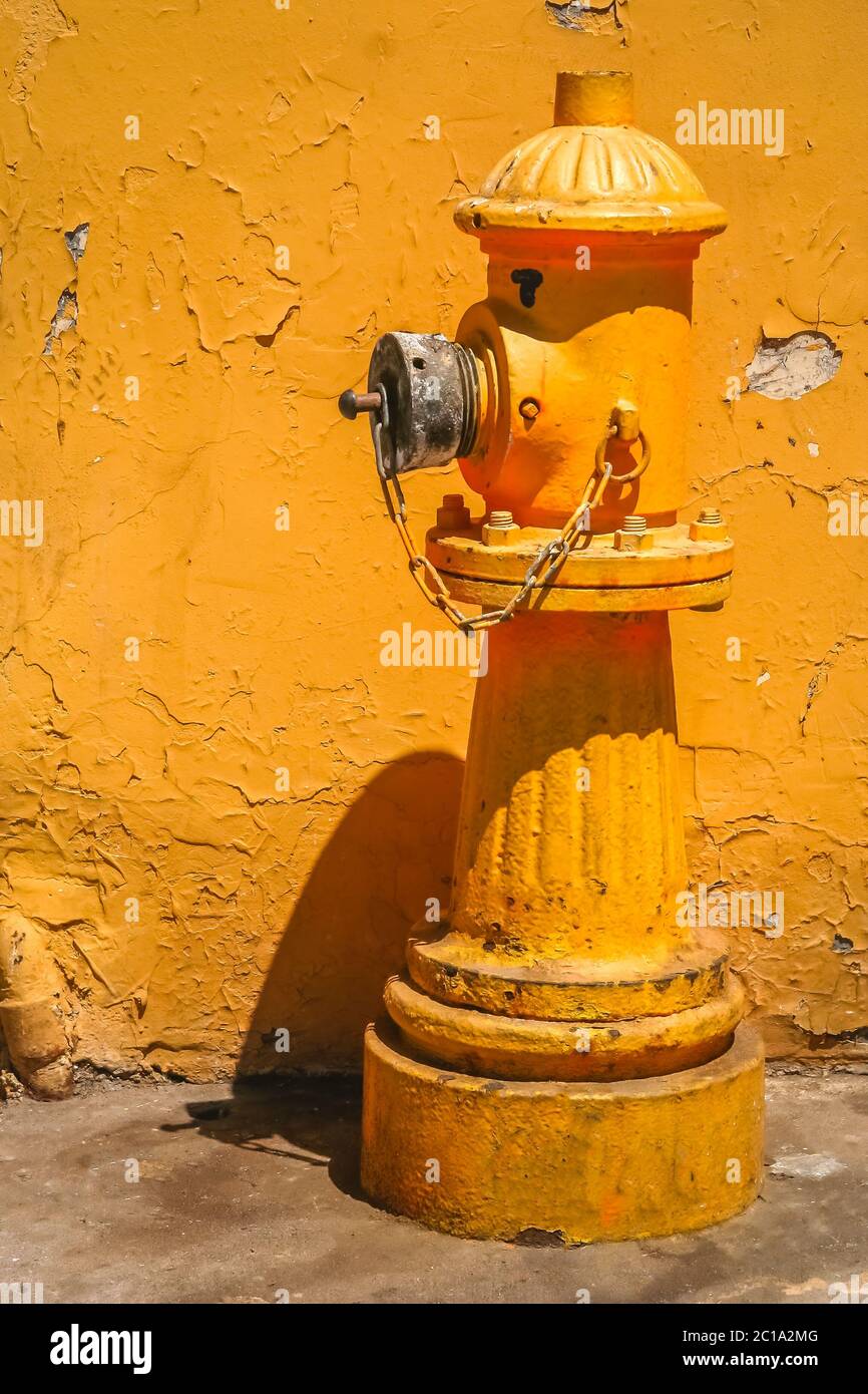 Yellow hydrant in front of the yellow building Stock Photo - Alamy