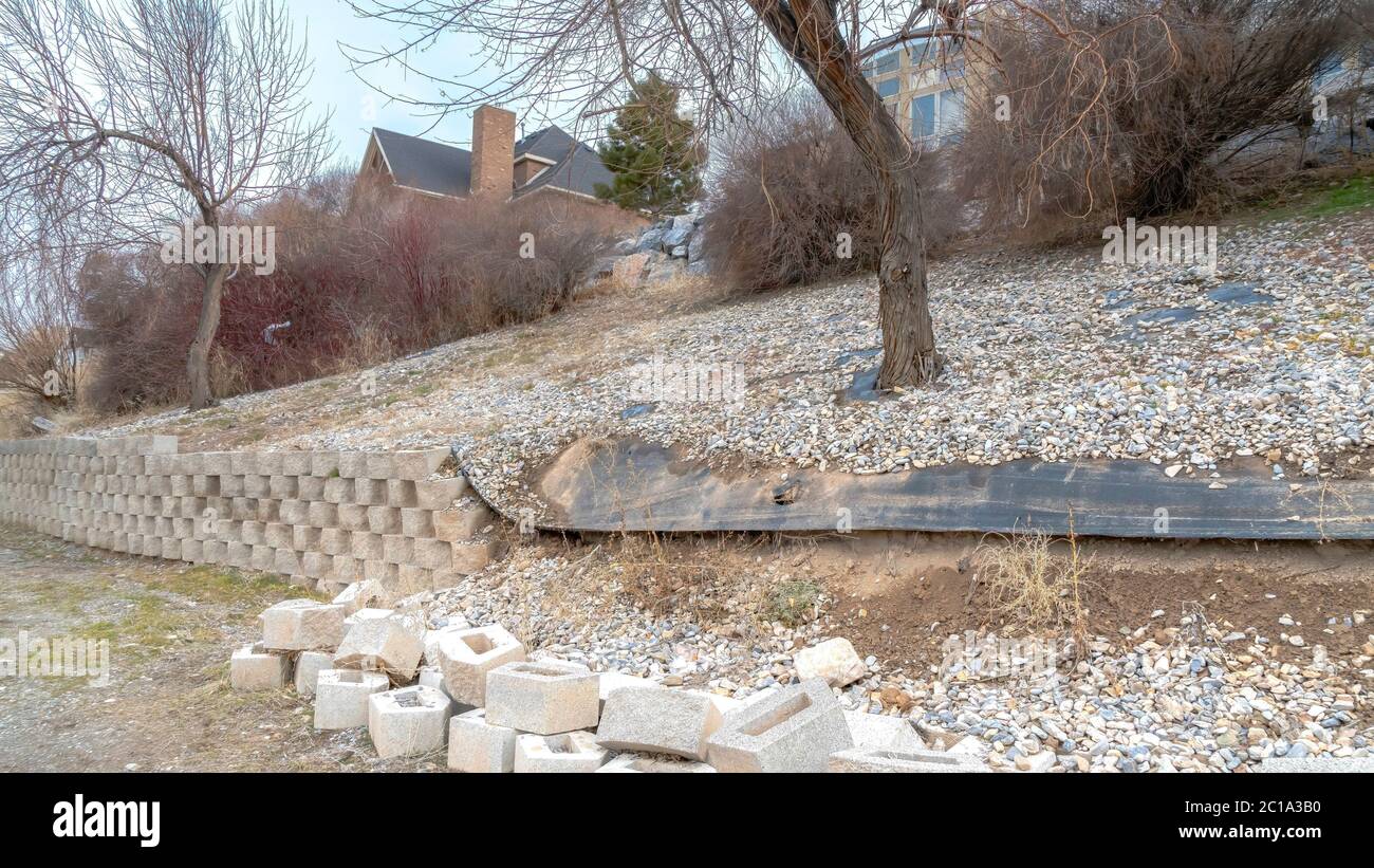 Panorama Stone blocks of collapsed retaining wall holding the soil of a ...