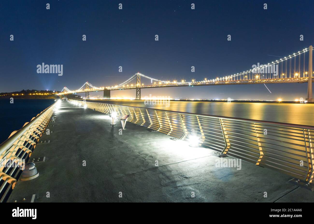 empty sidewalk and suspension bridge at night Stock Photo - Alamy
