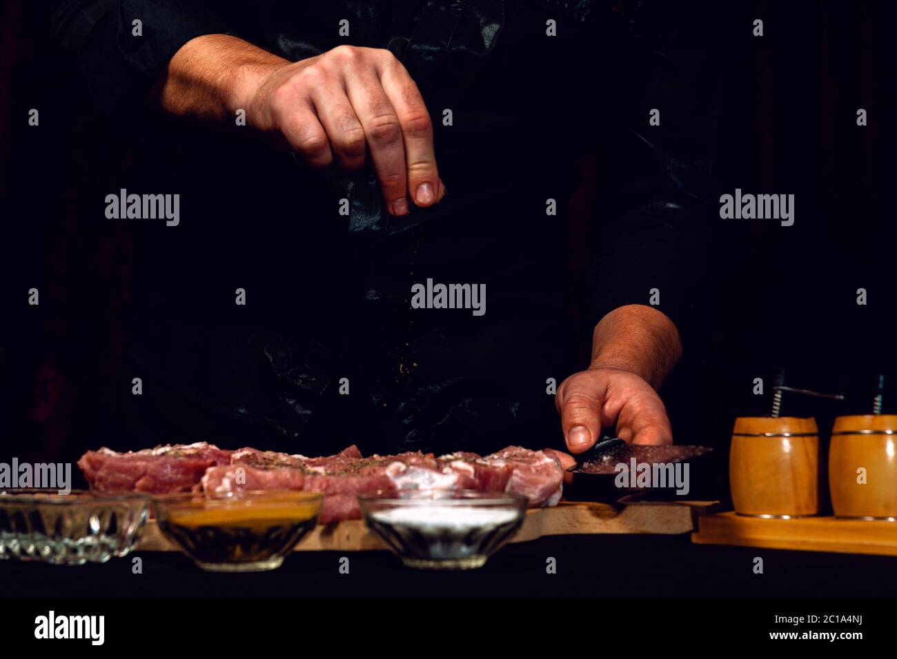 The chef of the restaurant sprinkles with curry spices and basil meat ...