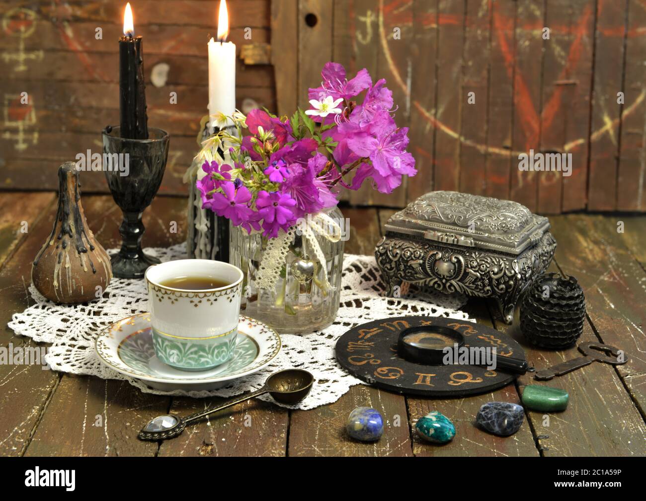 Still life with zodiac chart, black candle, cup and stones. Esoteric ...