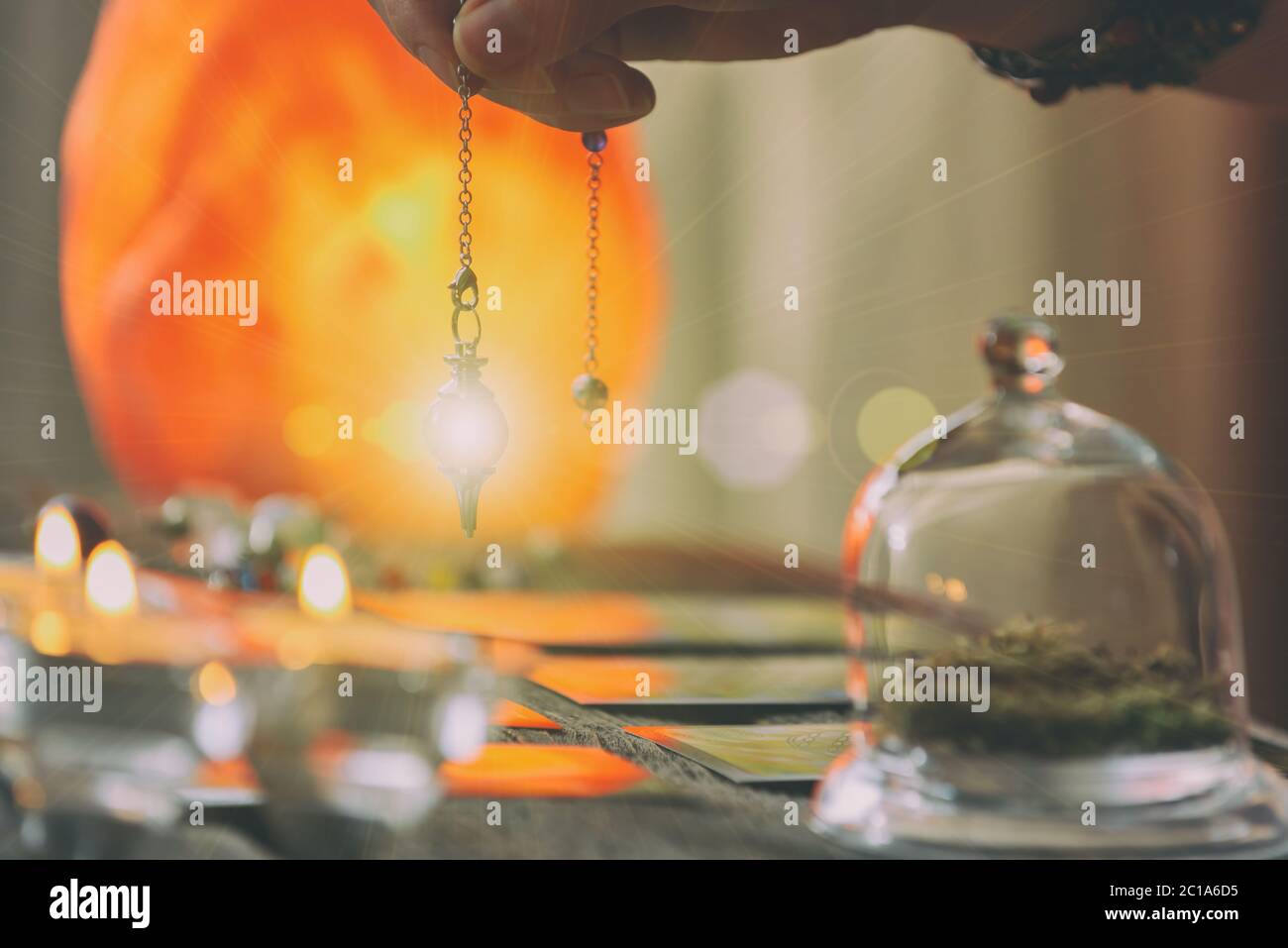 Fortune teller holding a pendulum over tarot cards Stock Photo - Alamy