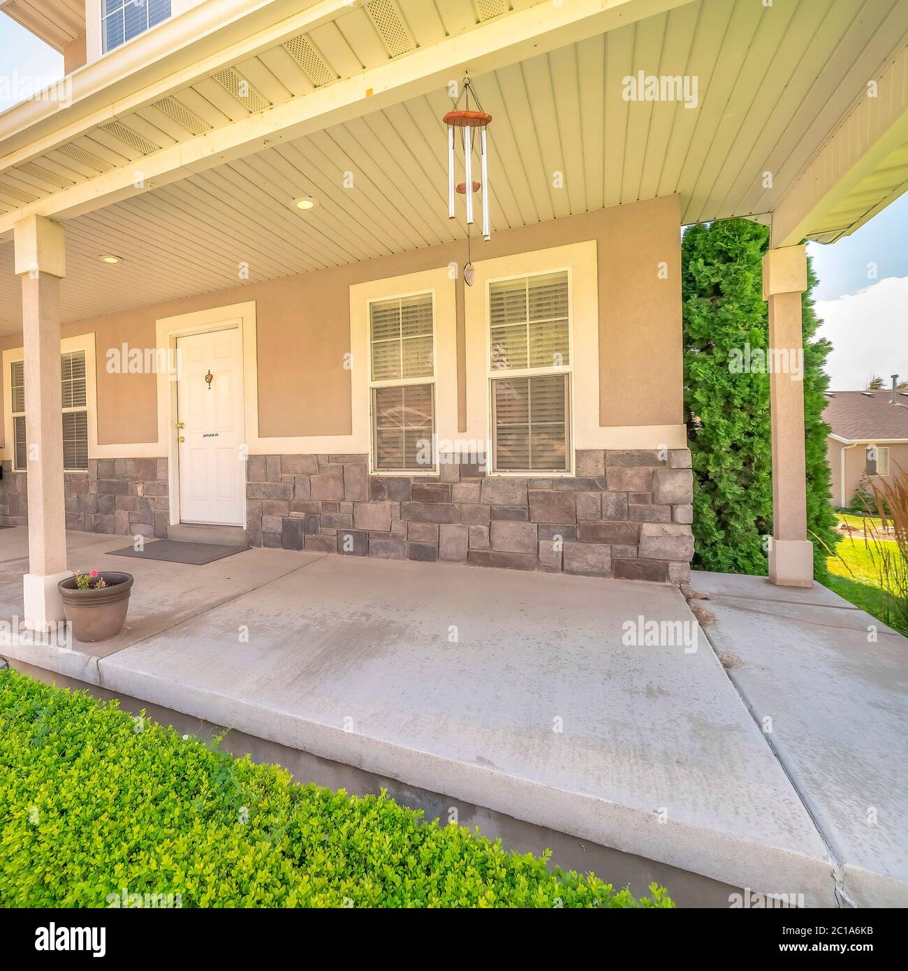 Square frame Home facade with concrete porch and white front door ...