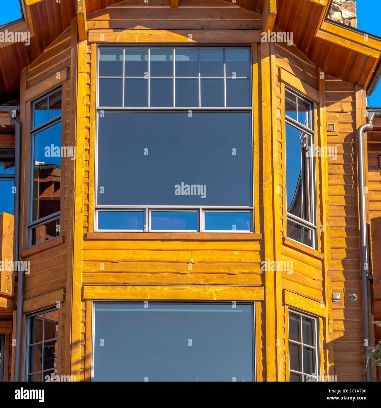 Square crop Multi storey home facade with large bay windows and wooden ...