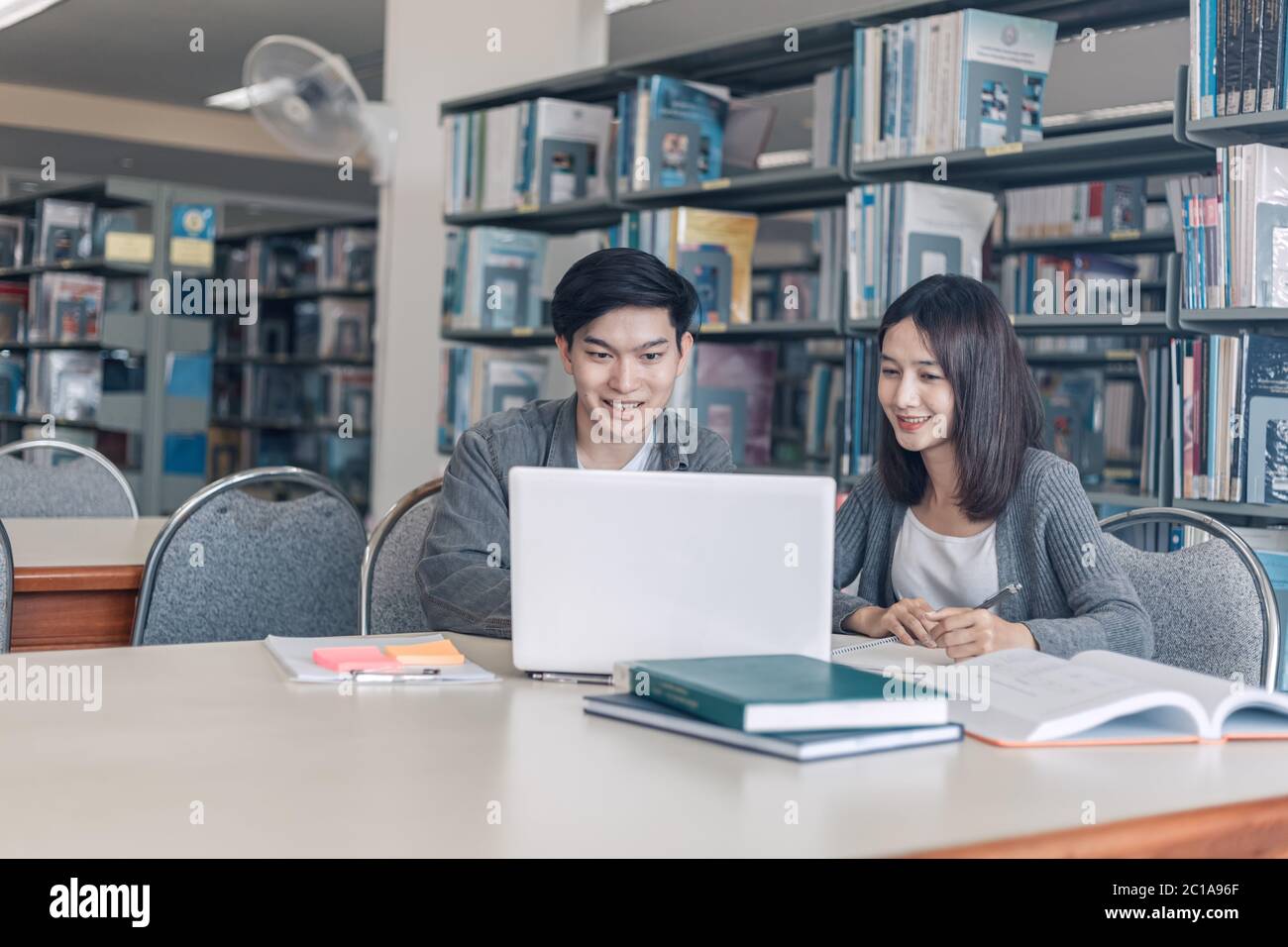 High school or college students studying and reading together in ...