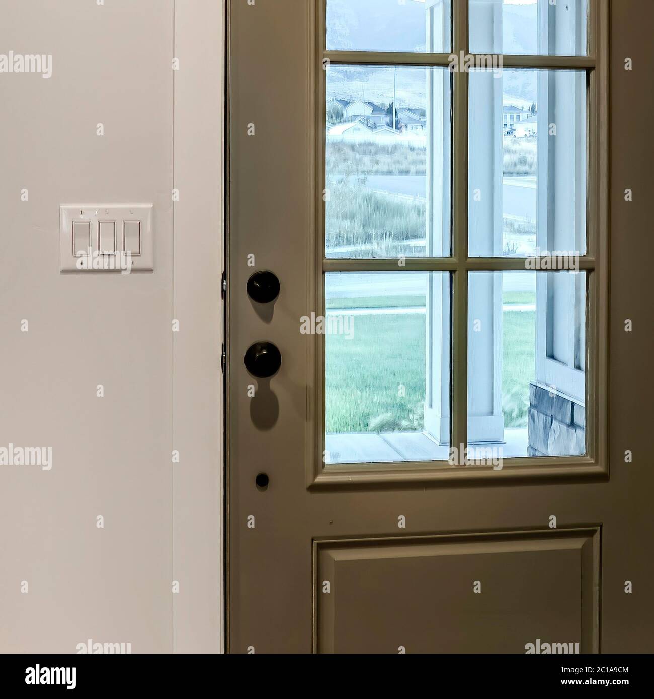 Square crop Hinged front door with glass pane viewed from interior of ...