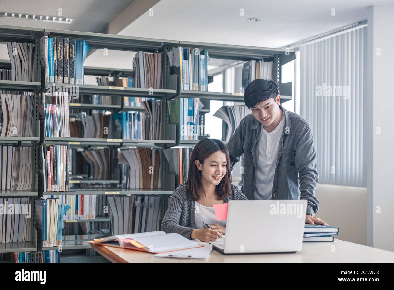 High school or college students studying and reading together in ...