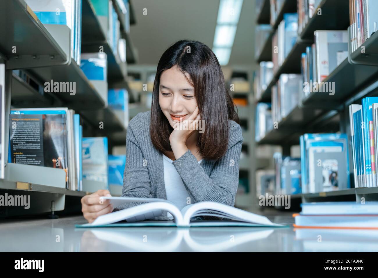Student college opening and reading a book at library Stock Photo - Alamy