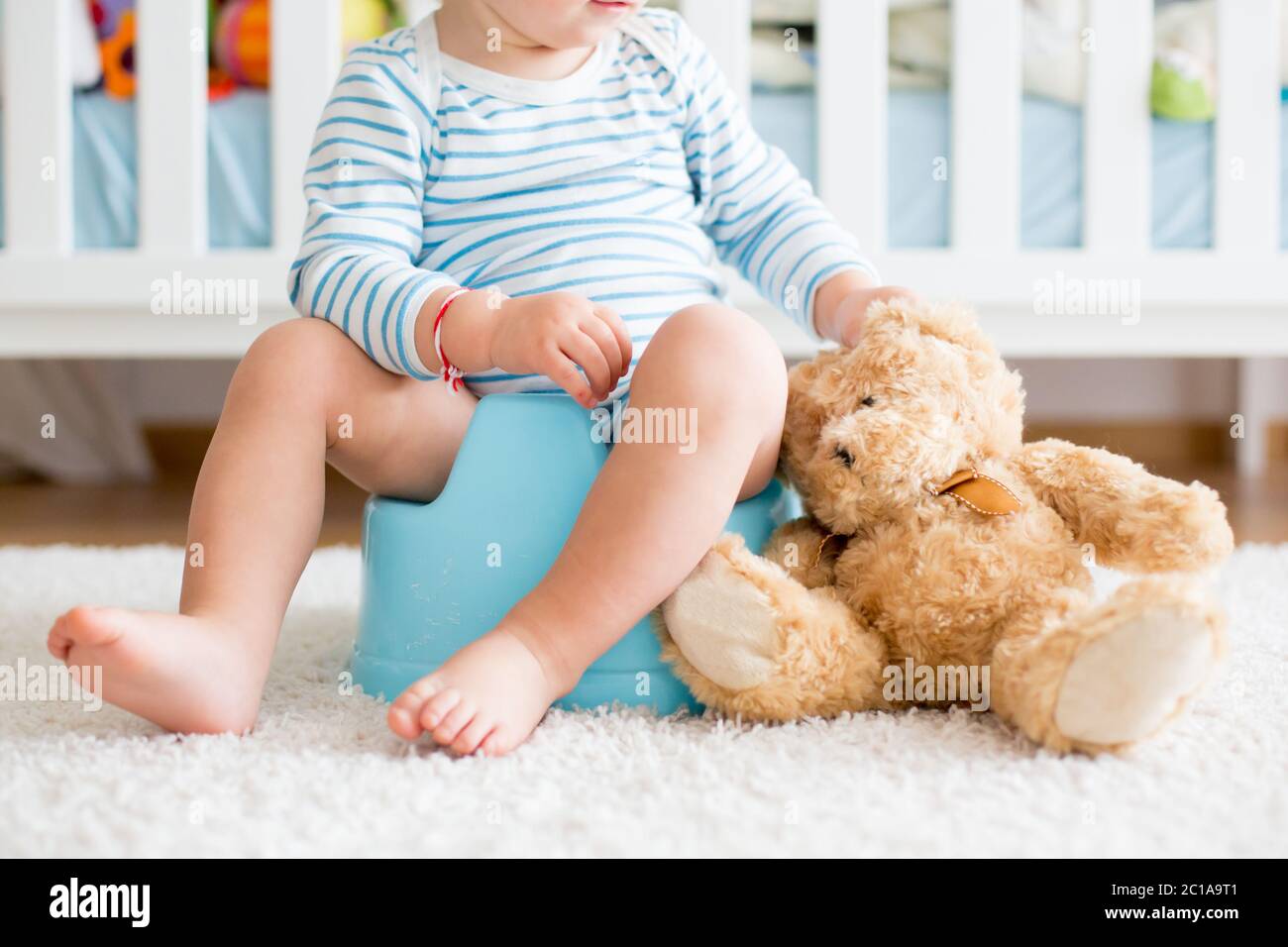 Cute toddler boy, potty training, playing with his teddy bear on potty ...