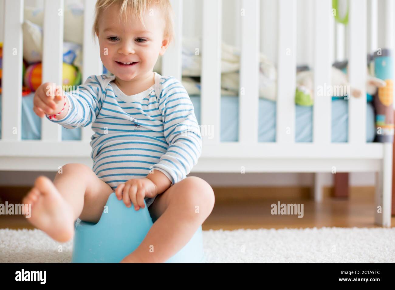Cute toddler boy, potty training, playing with his teddy bear on potty ...