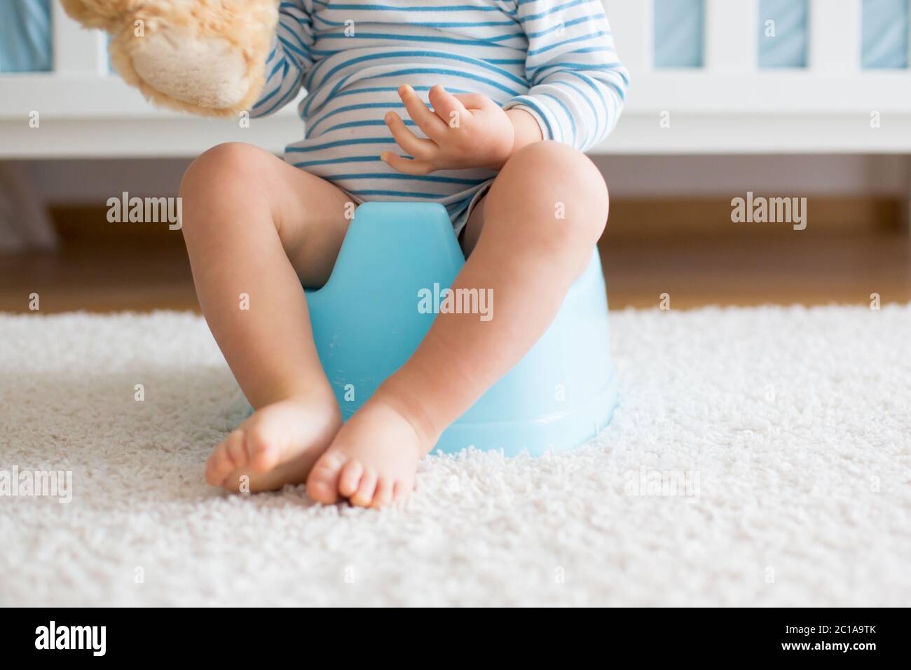 Cute toddler boy, potty training, playing with his teddy bear on potty ...