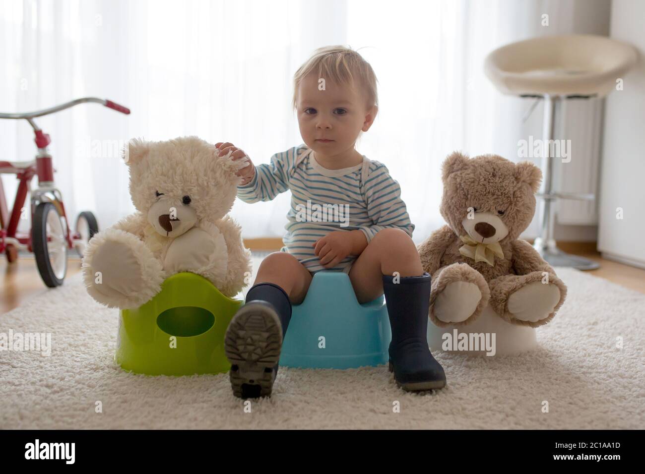 Cute toddler boy, potty training, playing with his teddy bear on potty ...