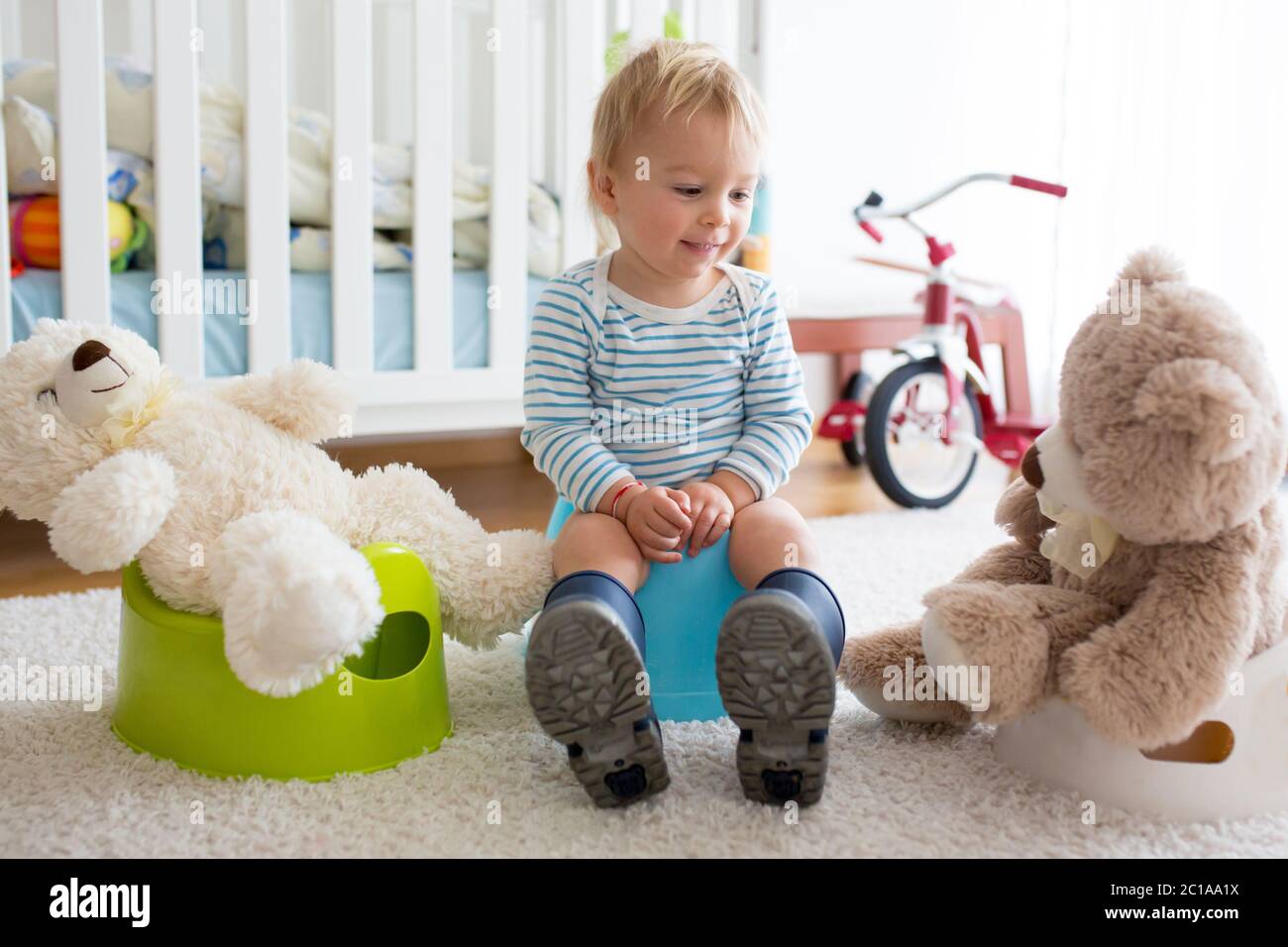 Cute toddler boy, potty training, playing with his teddy bear on potty ...
