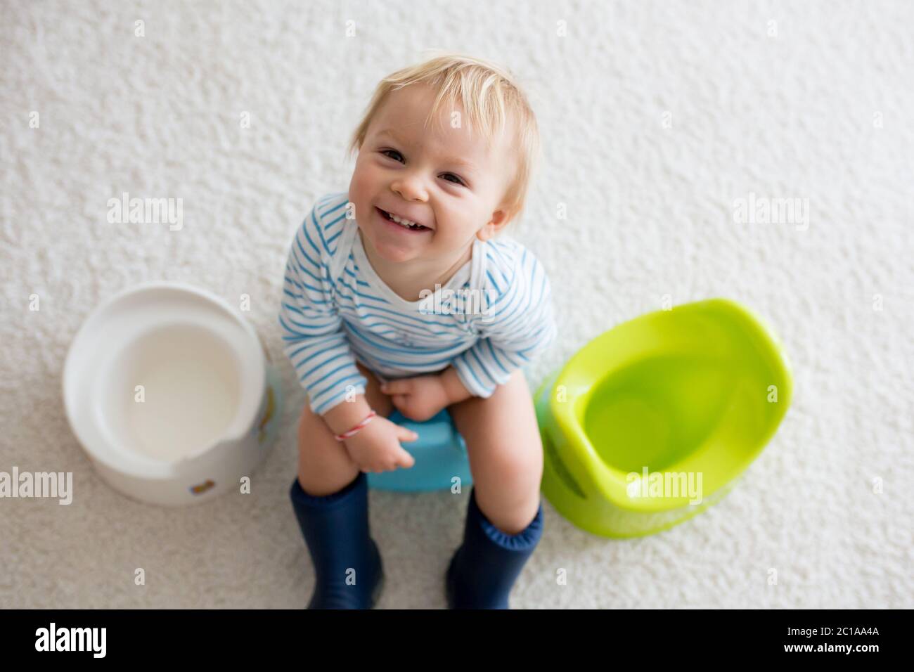 Cute toddler boy, potty training, playing with his teddy bear on potty ...