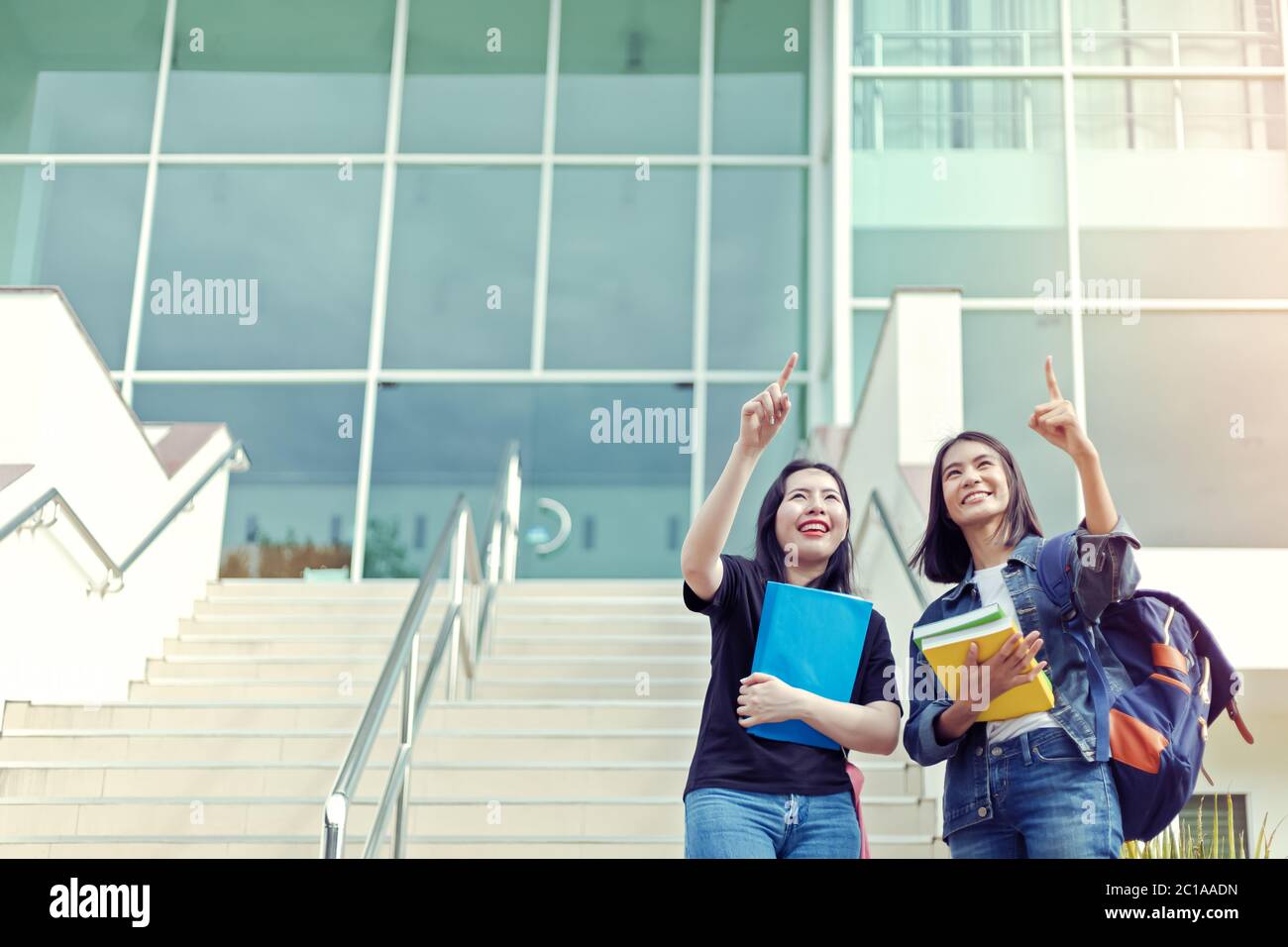 Two student Raised hands and hands point to sky at university ...