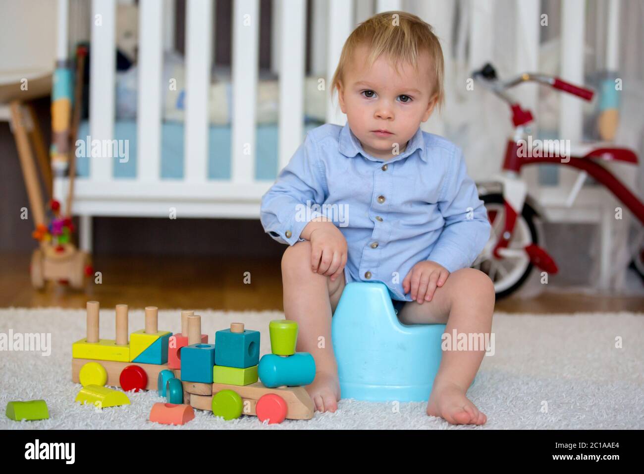Cute toddler boy, potty training, playing with his teddy bear on potty ...
