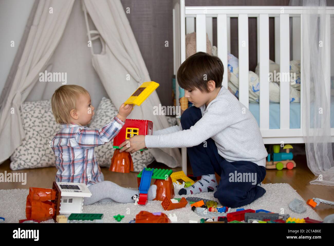 Brothers, sweet children, boys, playing with construction at home ...