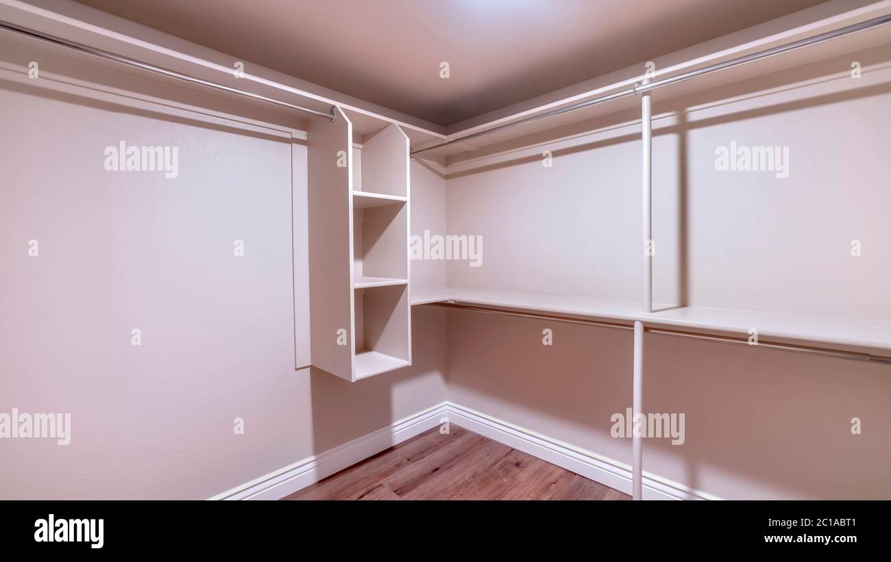 Panorama Spacious walk in closet of new home with metal rods shelves ...