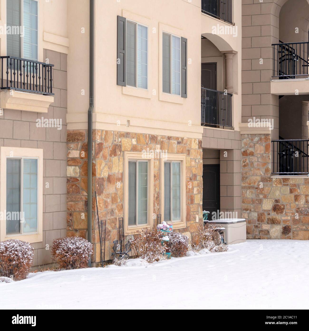 Square Residential apartment building facade with snow covered yard in ...